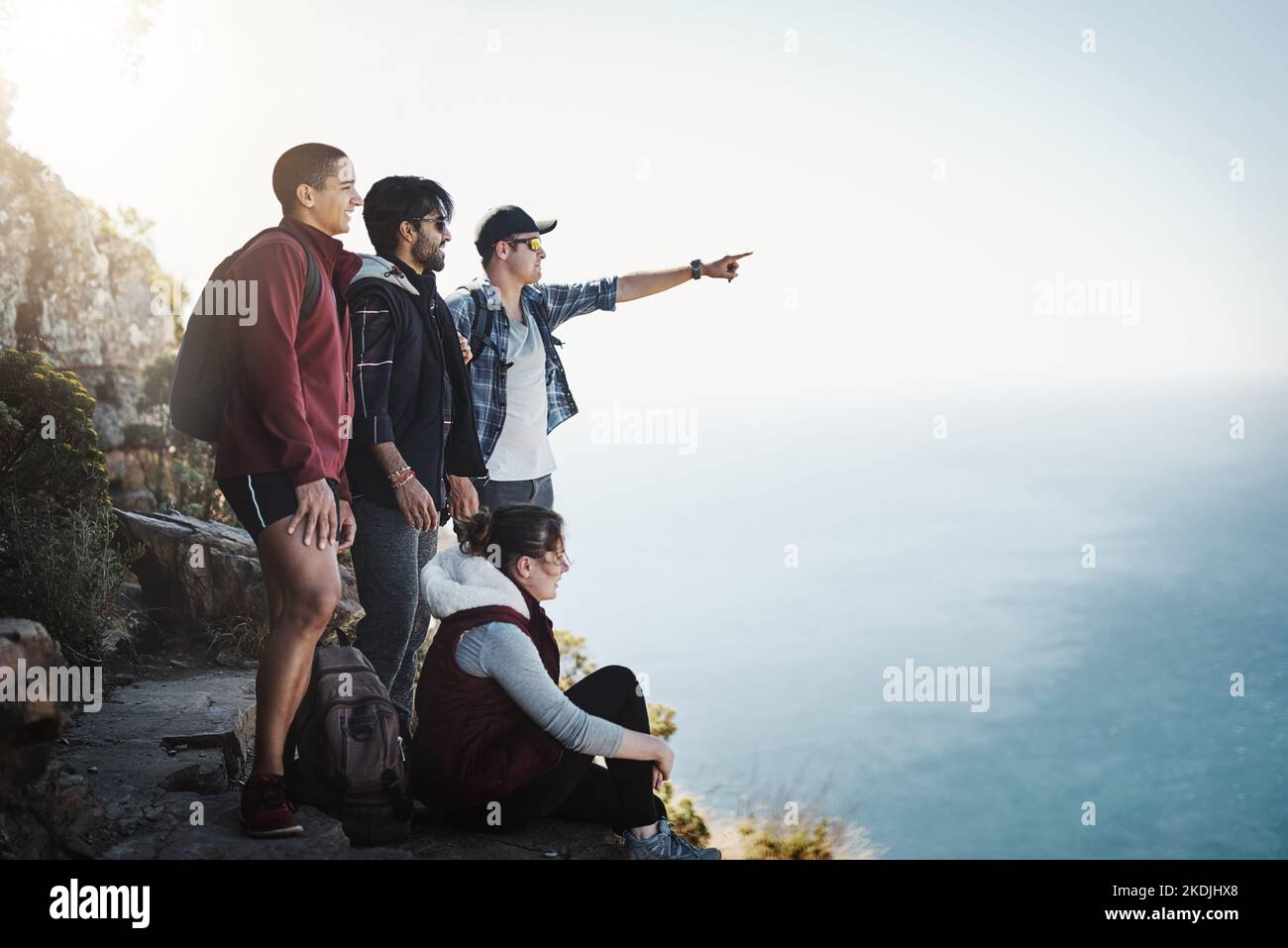 Look over there. a young man pointing something out to his friends ...