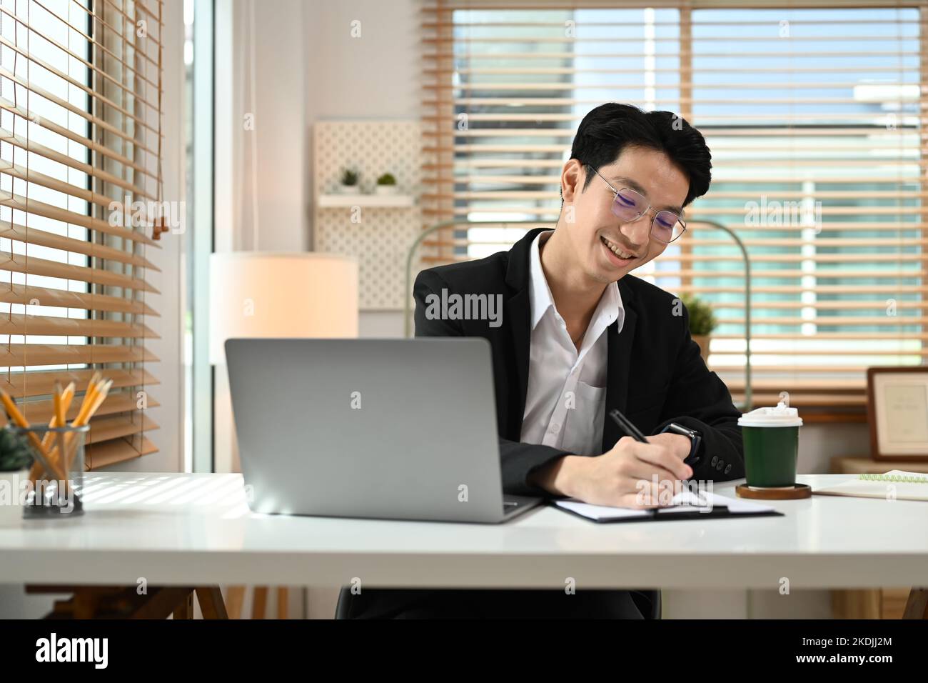 Happy young asian male entrepreneur using laptop computer and working ...