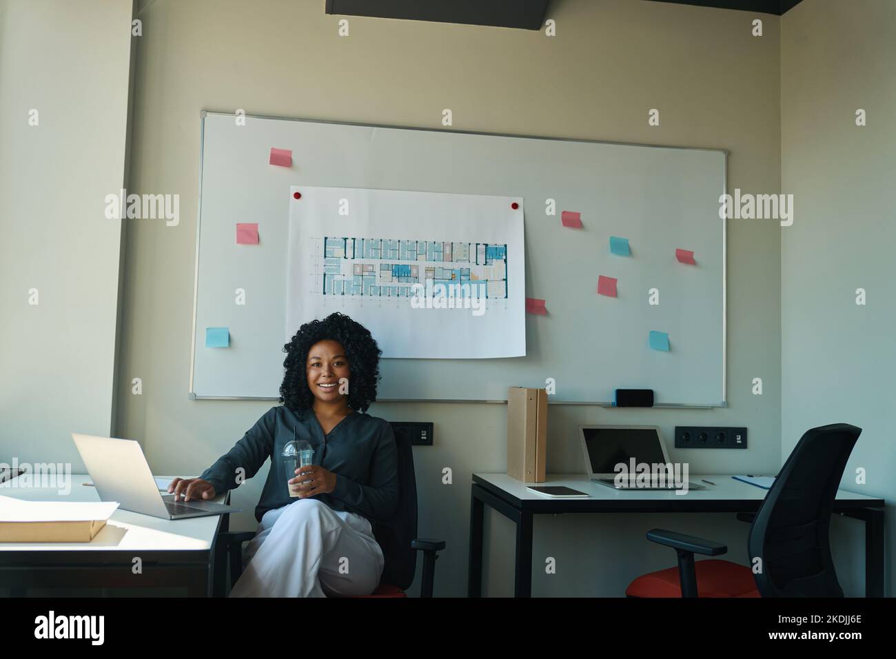 Multiracial female at workplace with coffee and laptop Stock Photo - Alamy