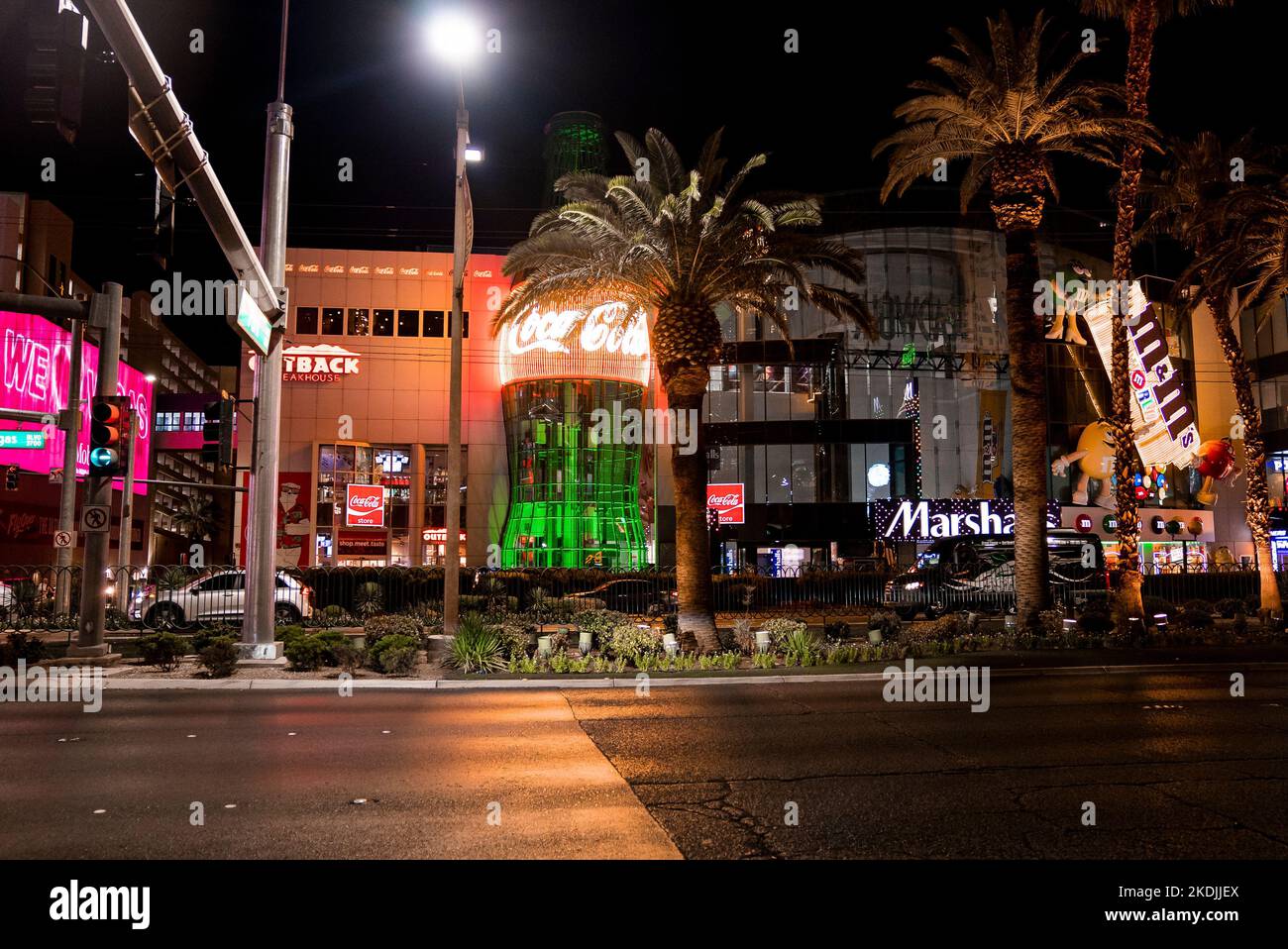 Various illuminated stores in modern buildings by road in famous city ...
