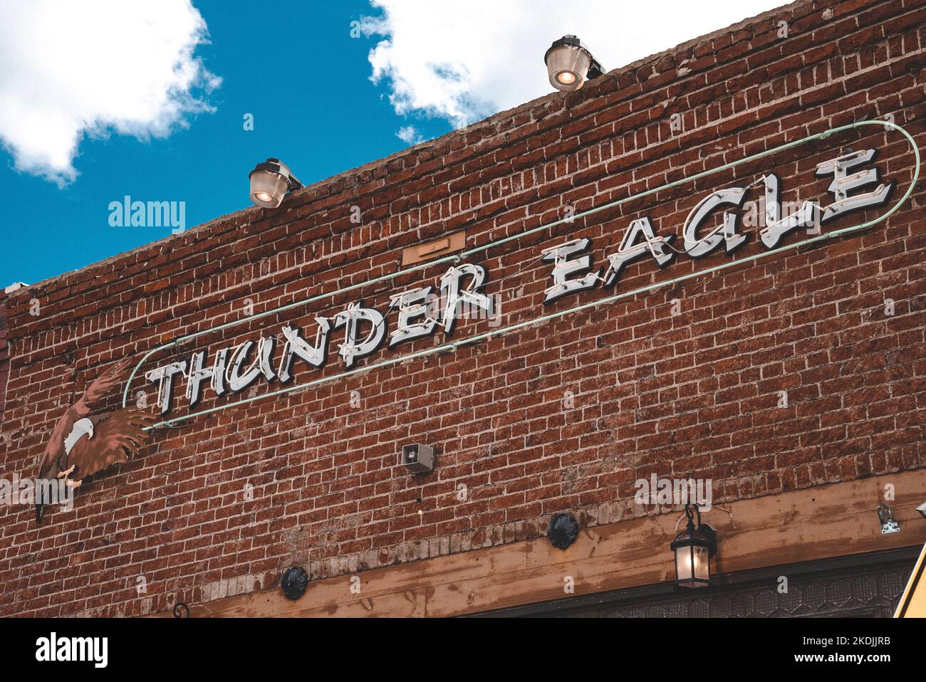 Electric signboard on brick wall at entrance of store with sky in ...