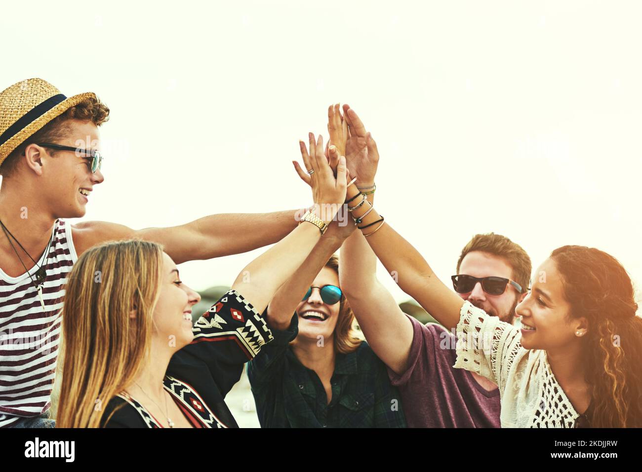 Yay us. a happy group of friends high fiving on the beach Stock Photo - Alamy