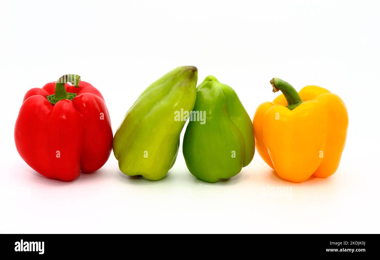 Four sweet ripe peppers of red, green and yellow color on a light ...