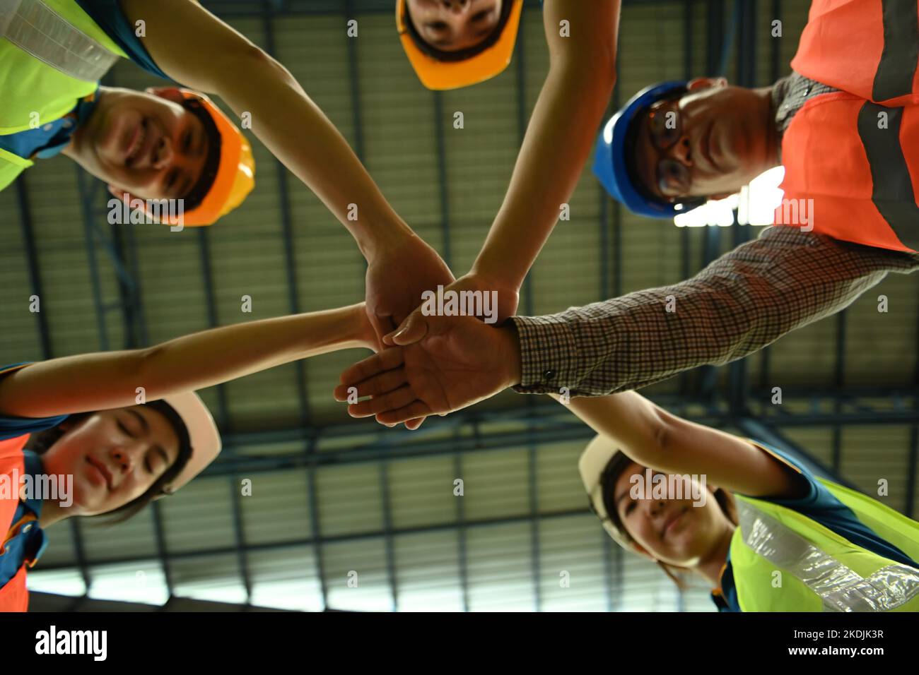 Smiling warehouse workers team stacking hands together bottom view ... Smiling warehouse workers team stacking hands together bottom view ...