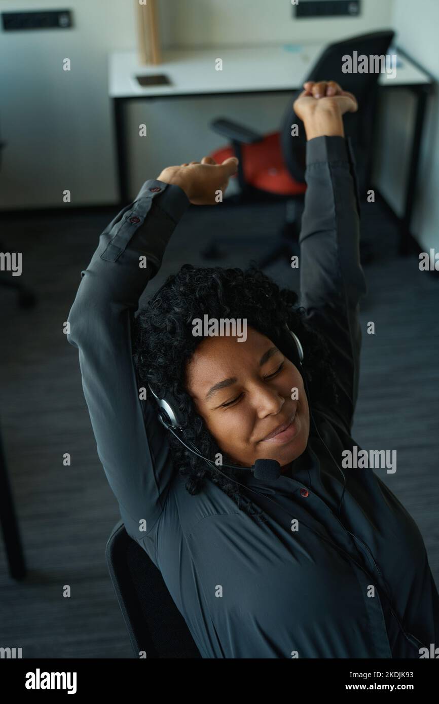 Multiracial female in call center stretching in an office chair Stock ...