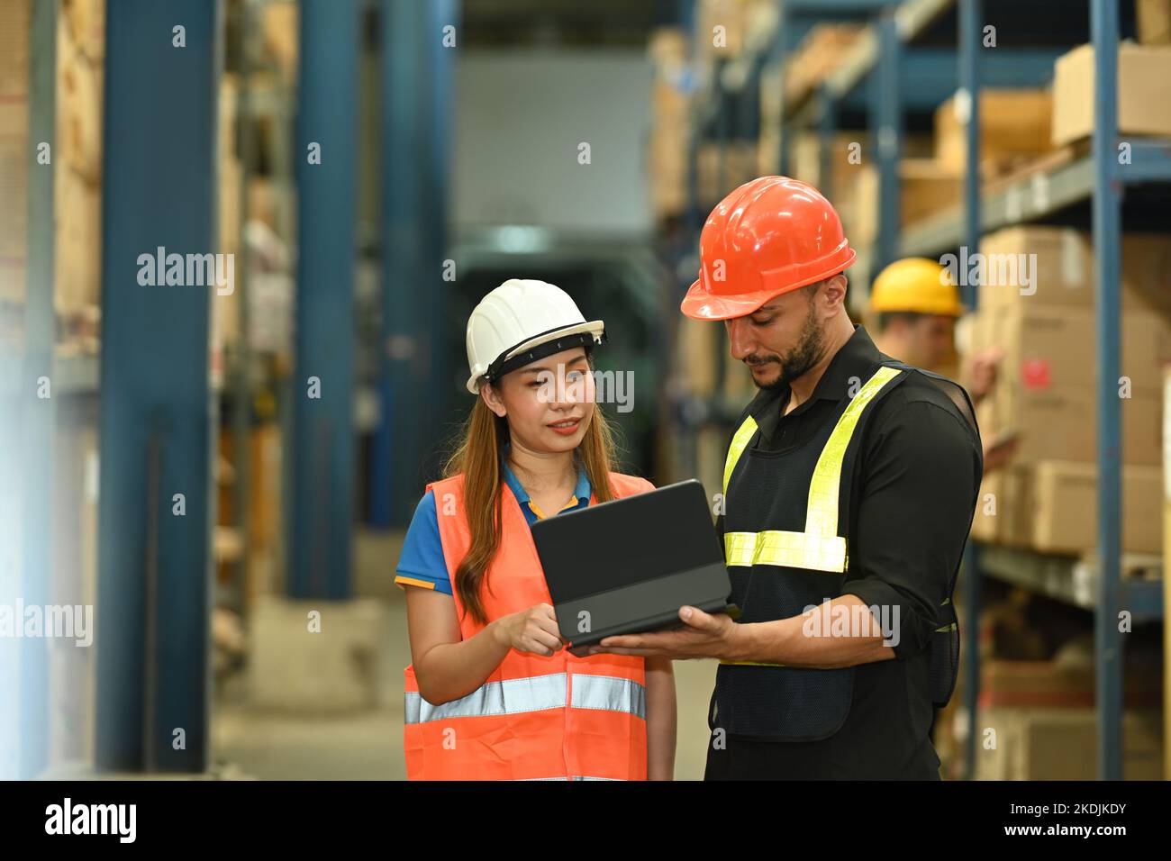 Male manager and female workers are checking order details on a tablet ...