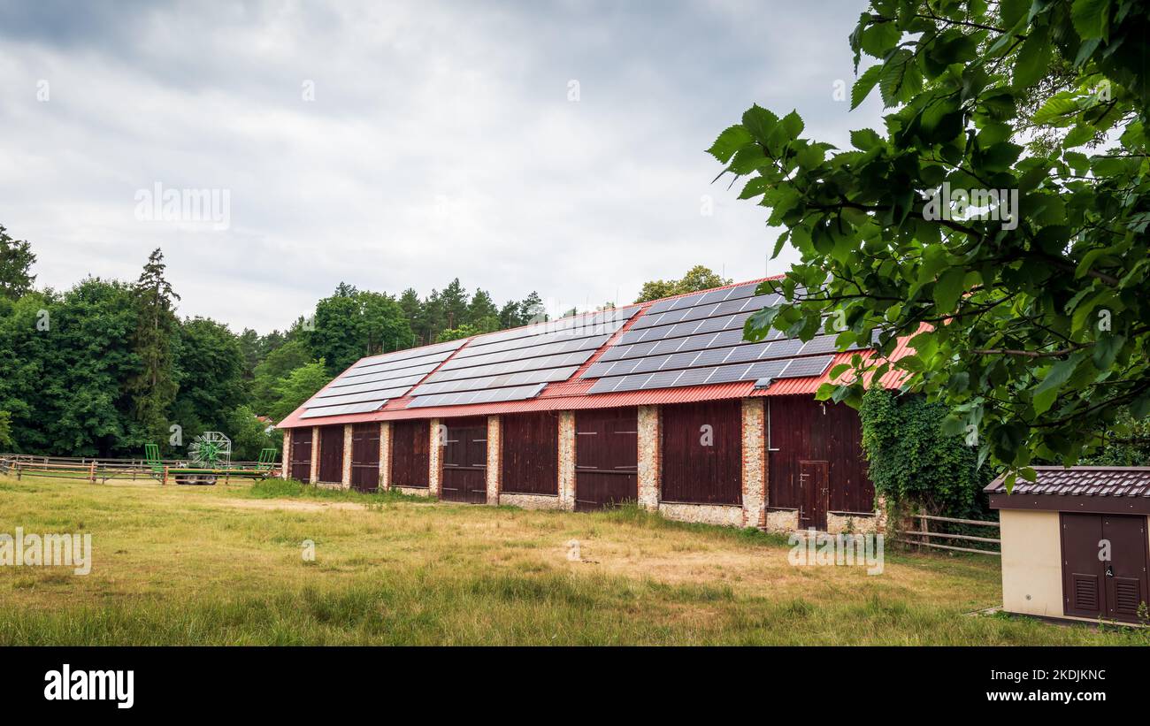 A huge brick barn with solar panels on the roof. Horse stud in ...