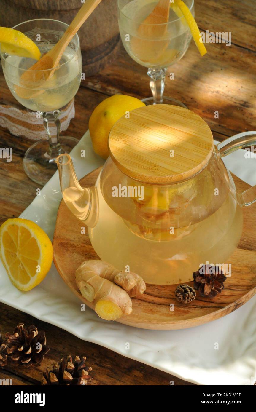 Ginger and lemon drink in the garden in a teapot and glasses ...