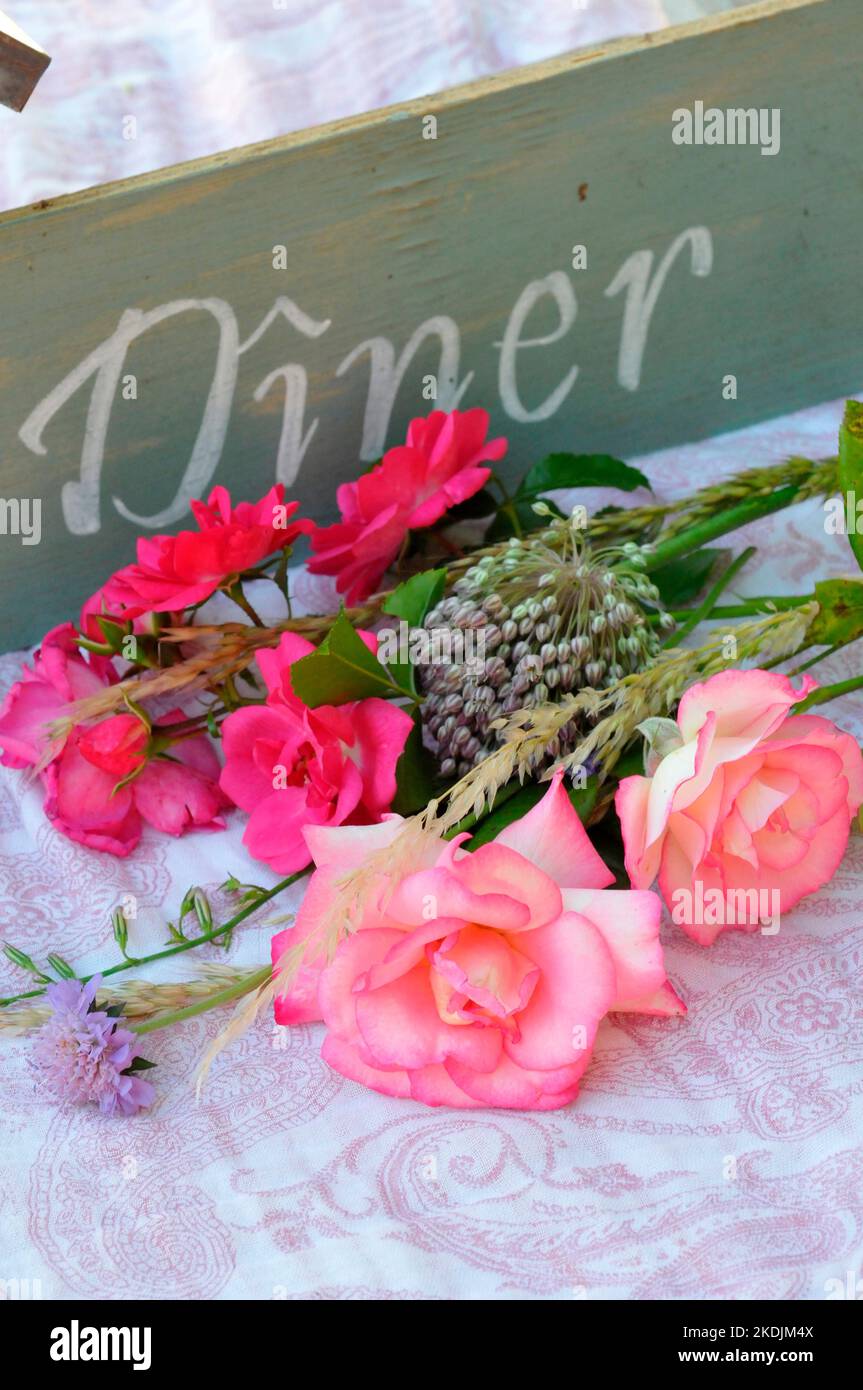 Emera Roses and other varieties, grey sign 'Dinner' message Stock Photo ...