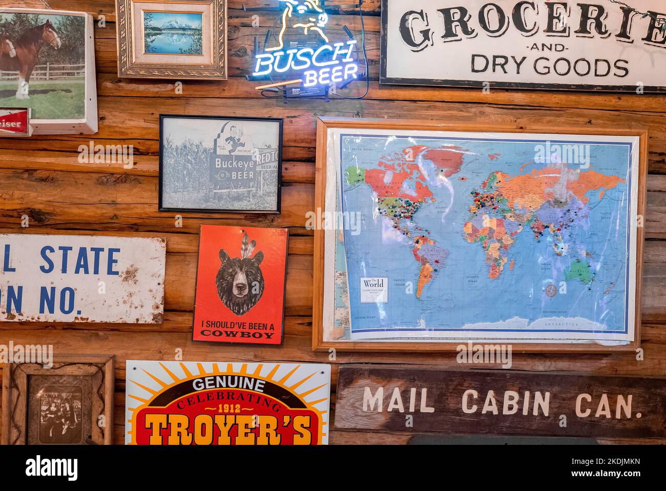 World map with various signboards mounted on wooden wall of restaurant ...