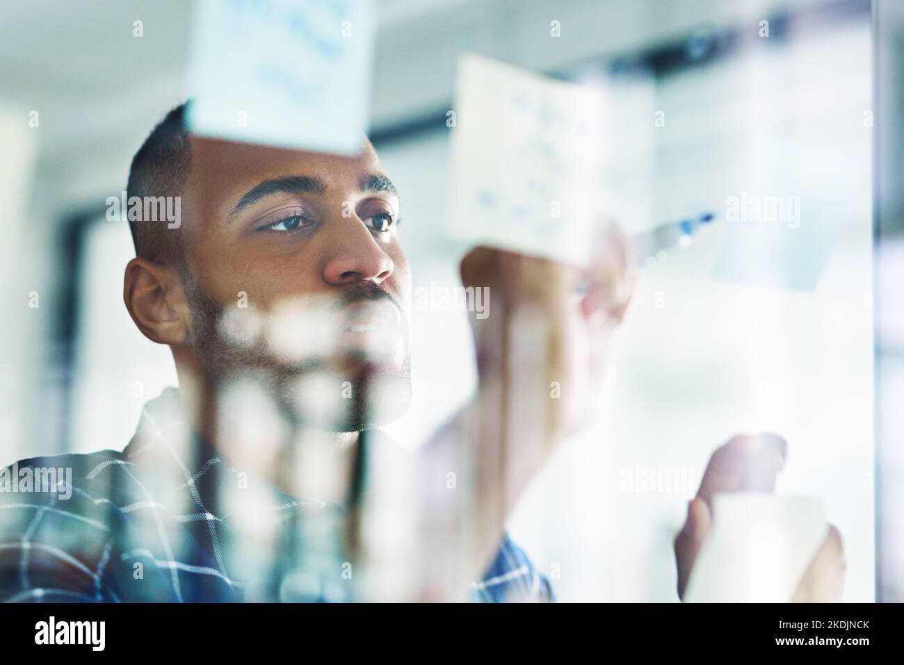 Planning for success. a handsome young businessman working on a glass ...