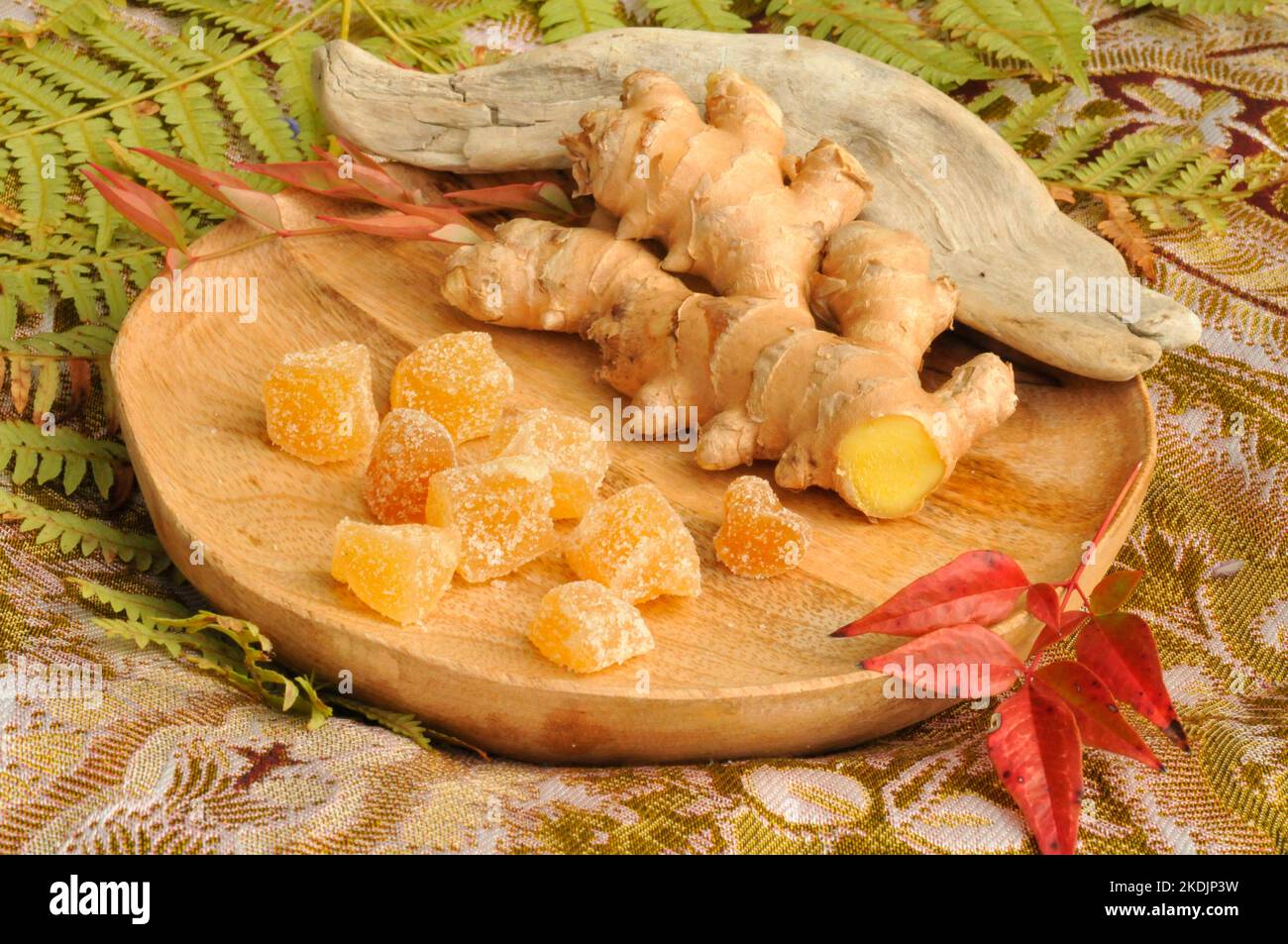 Ginger rhizome (Zingiber officinale) and candied fruit in a wooden ...
