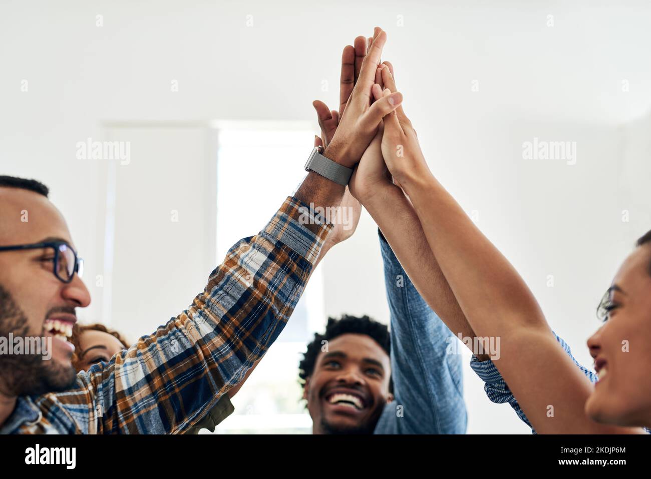 Time to work as a team. a group of colleagues giving each other a high ...