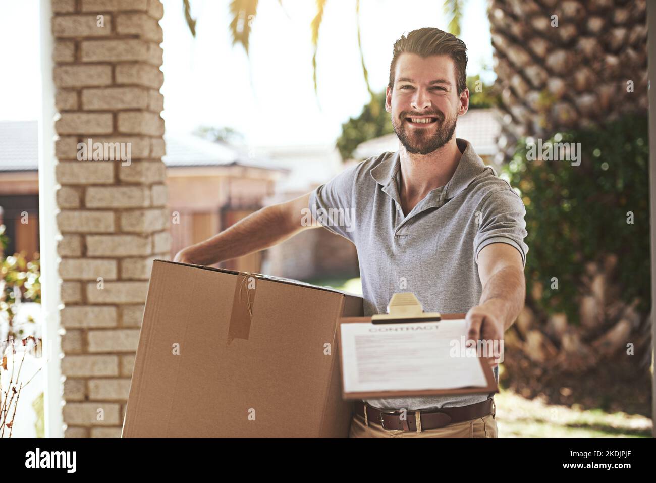 Delivered right to your door. a young delivery man making a home ...
