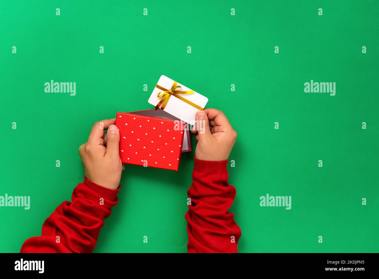 Female hands take out a bonus or gift bank card template from a gift ...