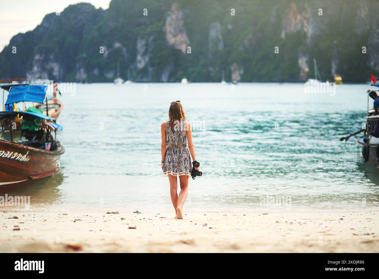Picture perfect days. Rear view shot of a young woman walking on the ...