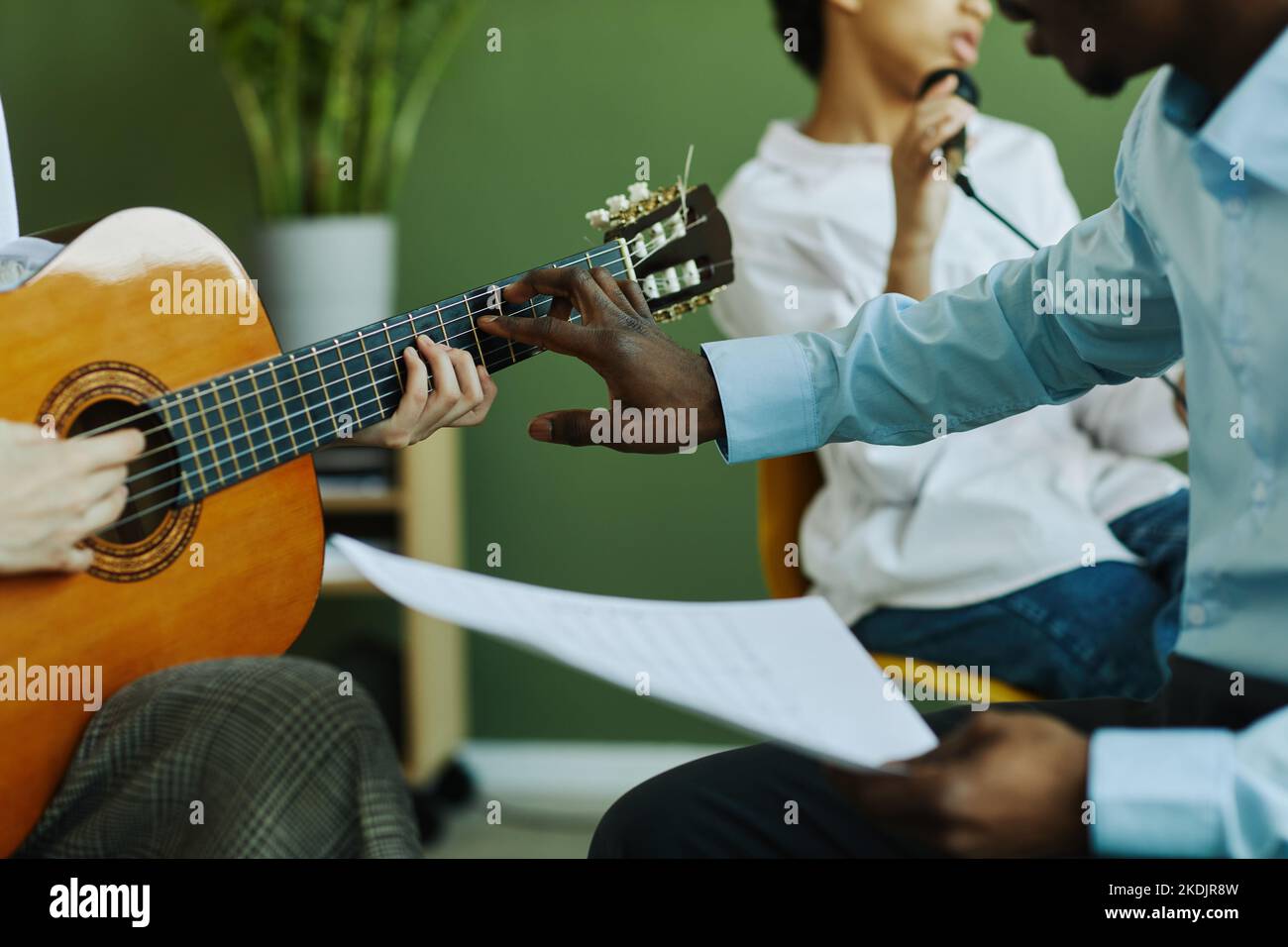 Close-up of hands of music teacher and learner touching strings of ...
