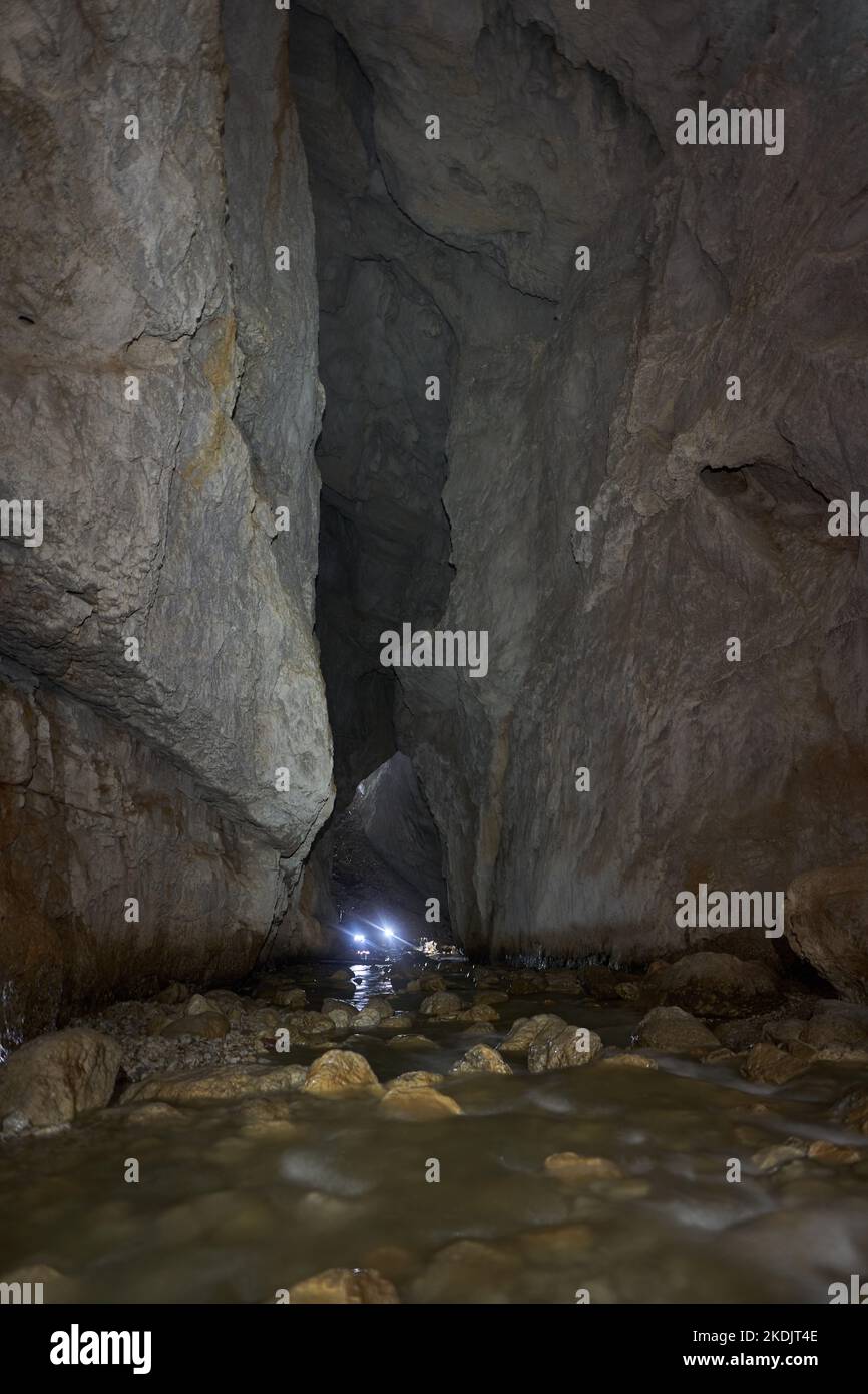 People with head lamps exploring the underground river and cave Stock ...