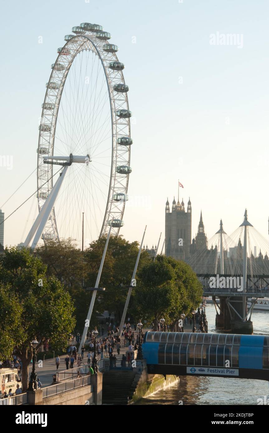 The London Eye from Waterloo Bridge, London, people walking alon the ...