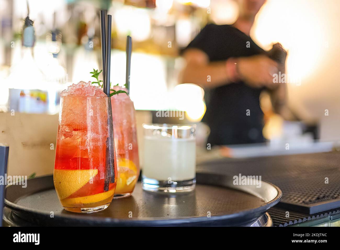 A classic cocktail glasses with barman out of focus in background Stock ...