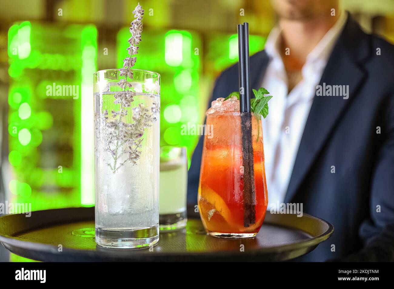 A night club waiter carries the tray with cocktails Stock Photo - Alamy