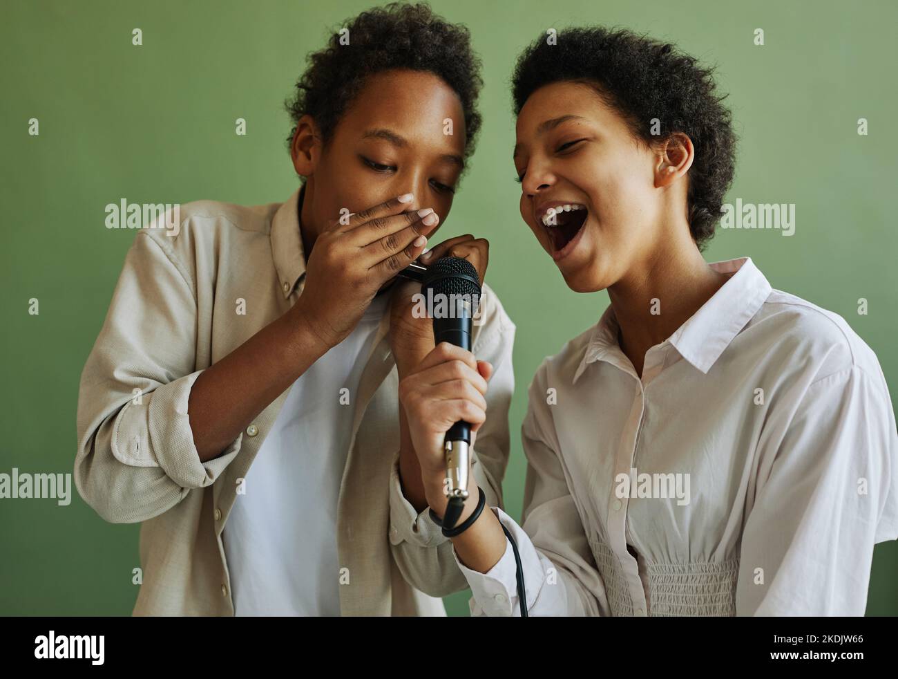 Youthful African American boy and girl performing song together during ...