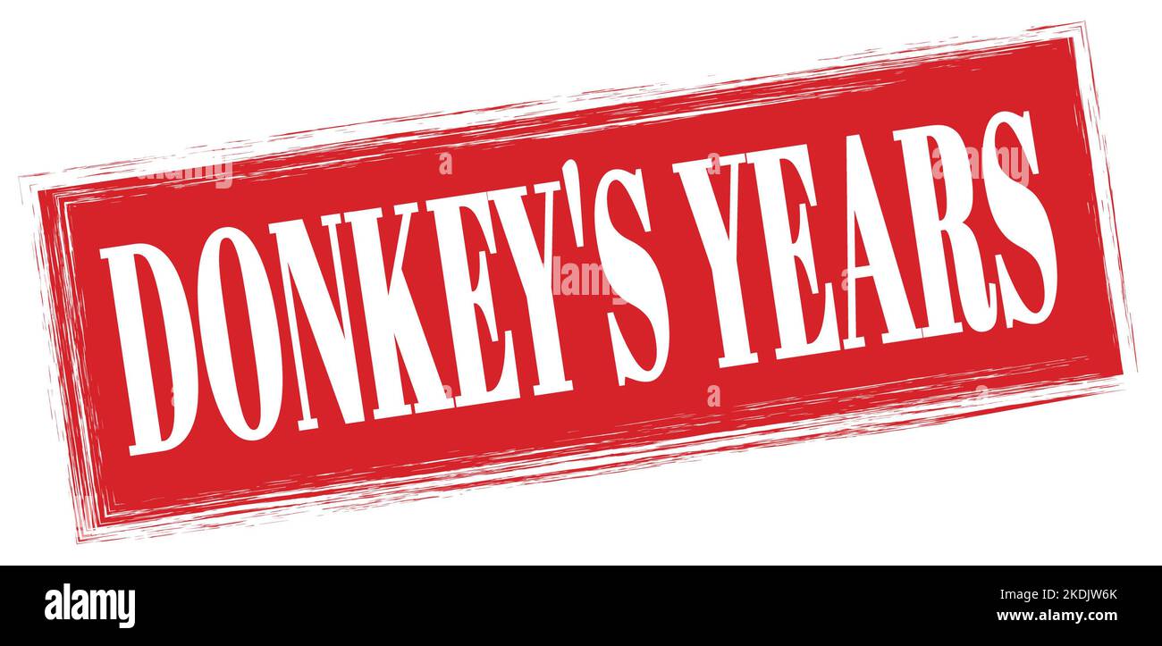 DONKEY'S YEARS text written on red rectangle stamp sign Stock Photo - Alamy
