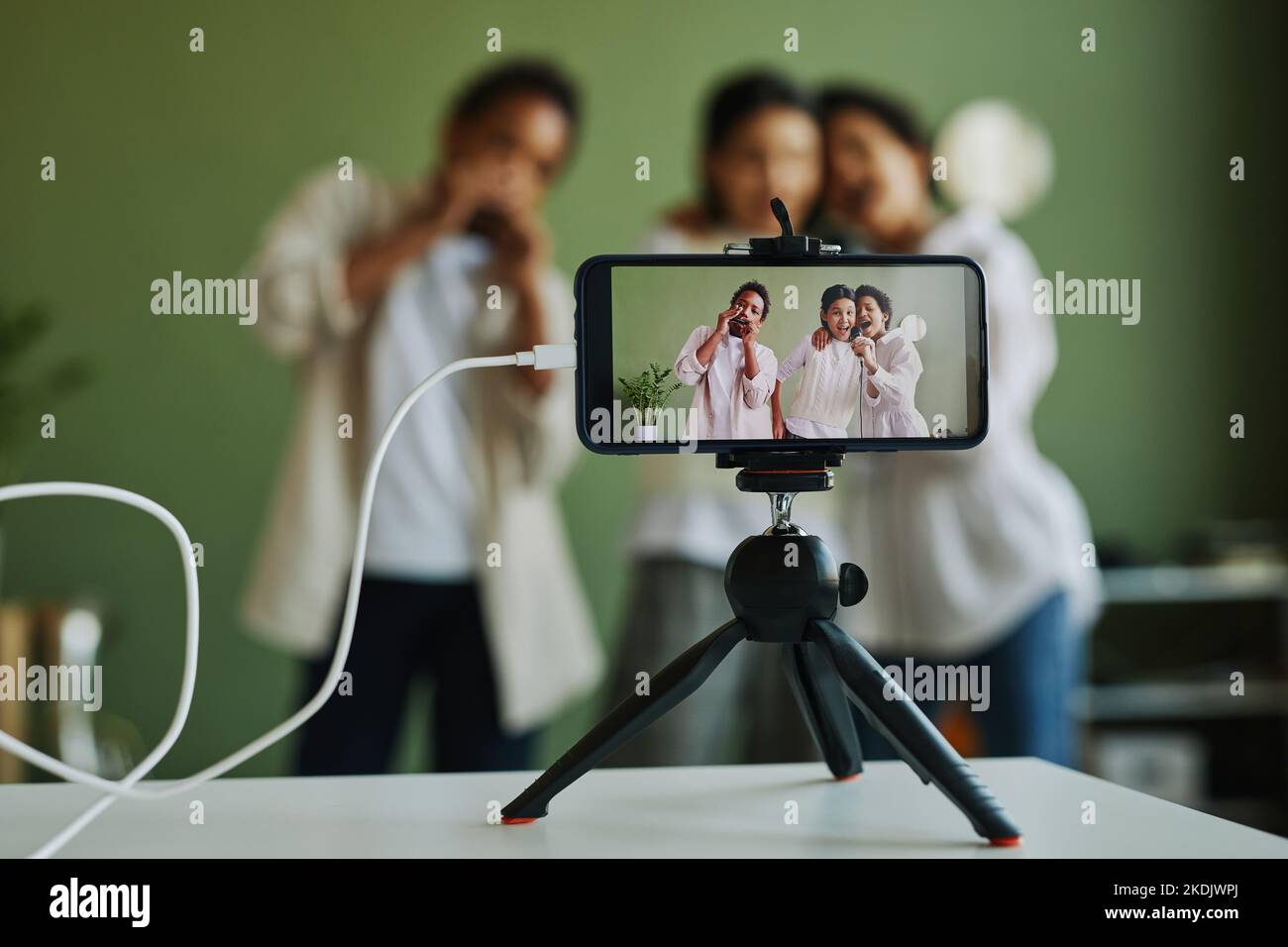 Group of happy intercultural kids performing song on smartphone screen ...