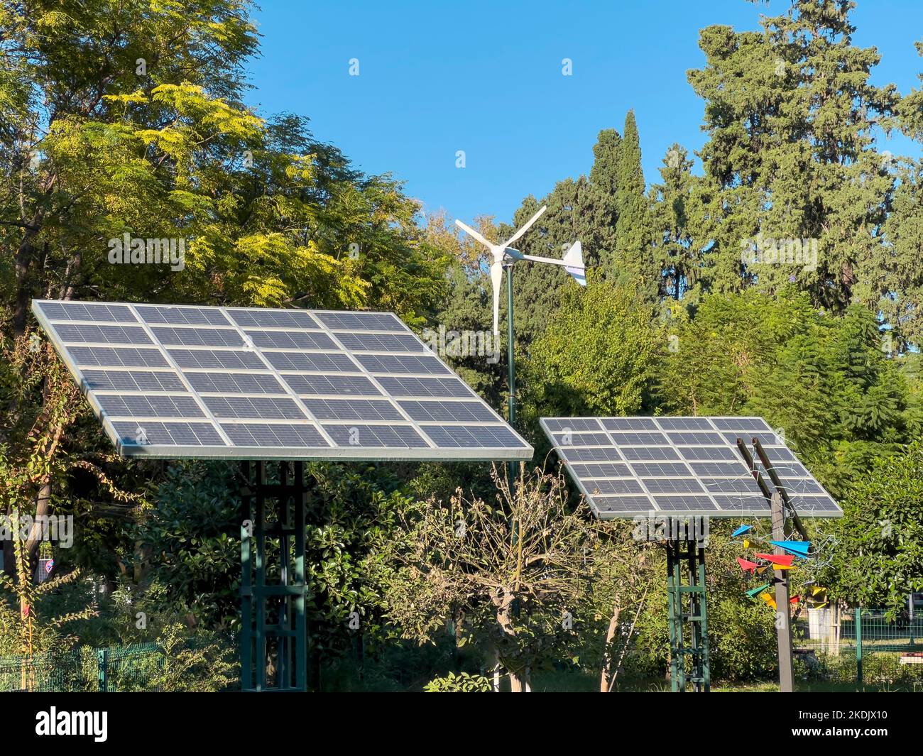 Wind turbine and solar panel installed in the green park area Stock ...