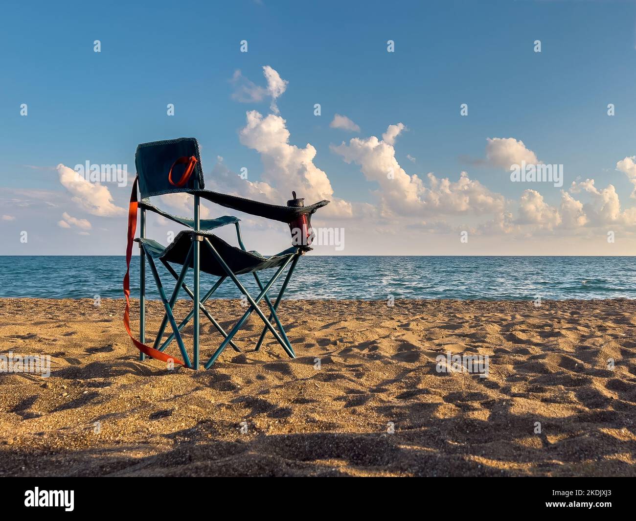 Folding camping chair facing the sea on the beach in the evening in ...