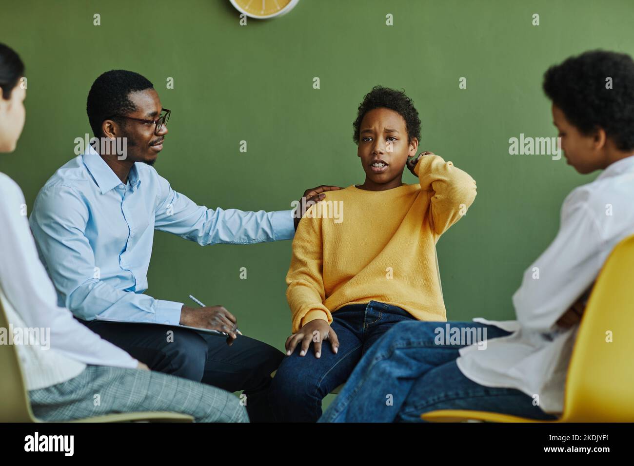 Dissatisfied schoolboy touching back of head while describing his ...