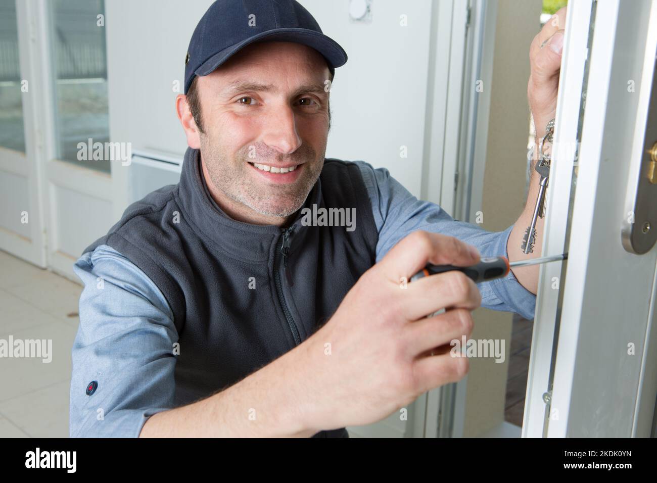 worker posing while mending a door Stock Photo - Alamy