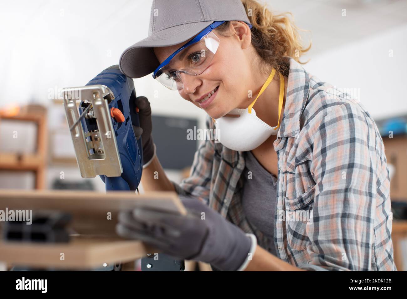 a female worker using electric jigsaw Stock Photo - Alamy
