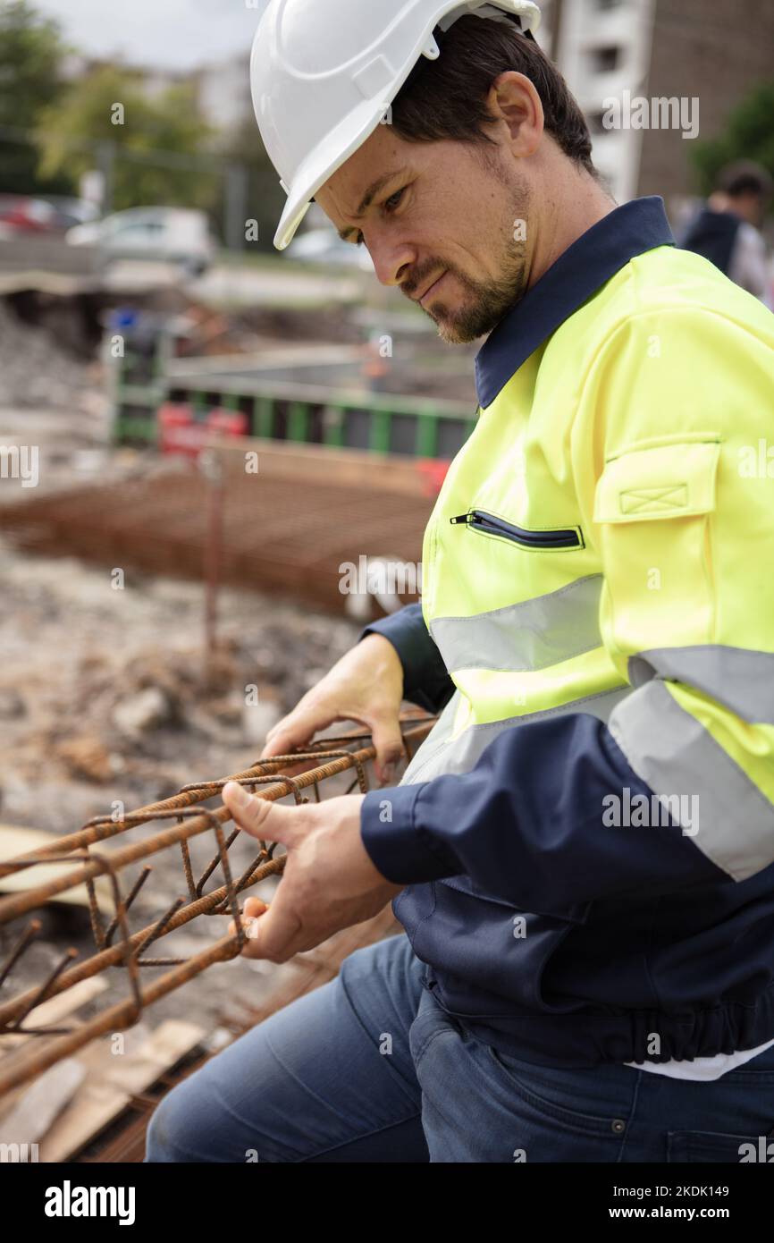 workman assembling metal rebars on outdoor site Stock Photo - Alamy