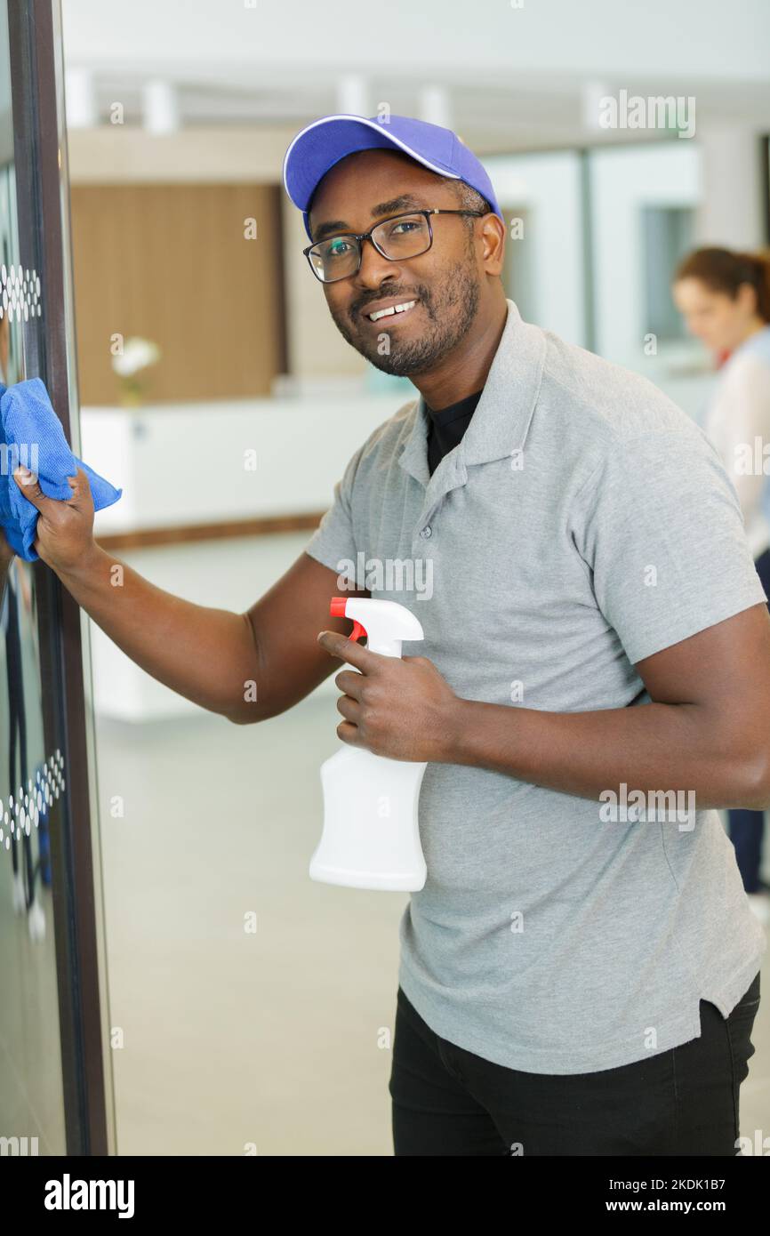 male cleaner using spray in hotel lobby Stock Photo - Alamy