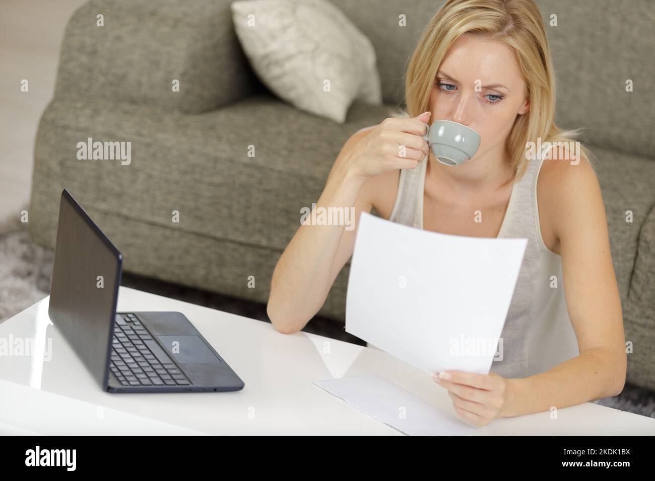 beautiful woman drinking coffee while reading a letter Stock Photo - Alamy