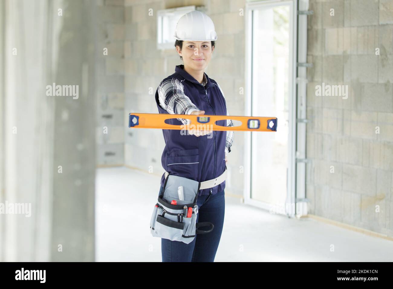 female builder using spirit level indoors Stock Photo - Alamy