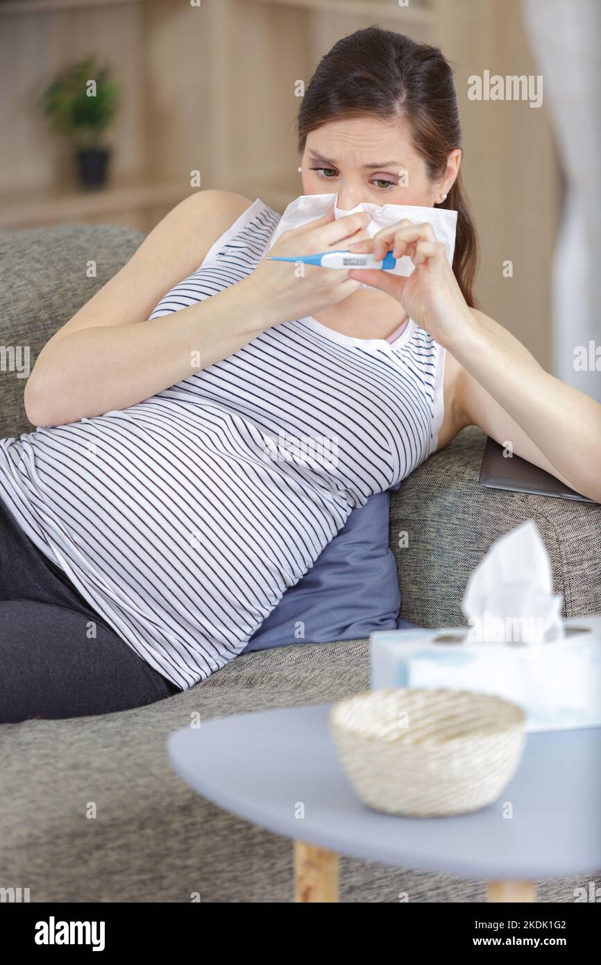 pregnant woman with temperature holding thermometer Stock Photo - Alamy