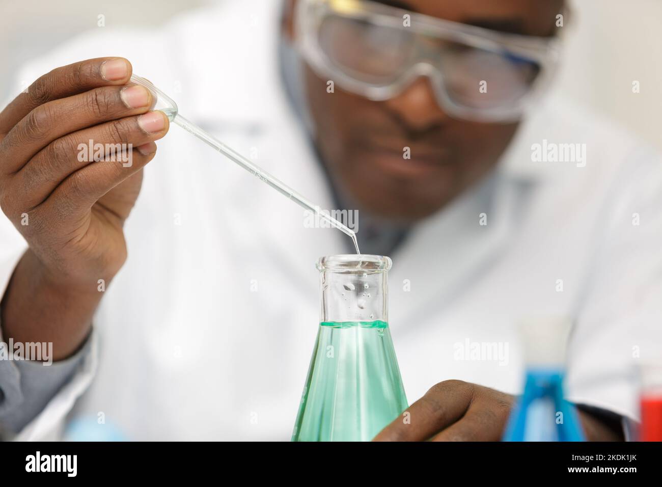 glass laboratory chemical test tubes with liquidman wears protective ...
