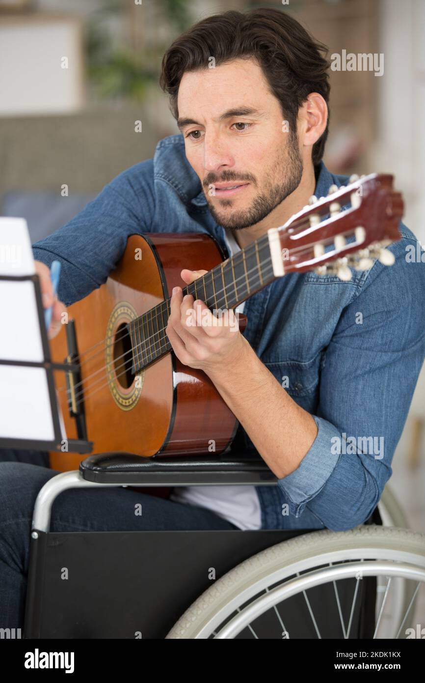focused musician on a wheelchair playing guitar Stock Photo - Alamy