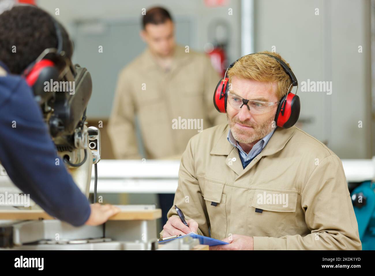 two men at work operating machine for cutting wood panels Stock Photo ...