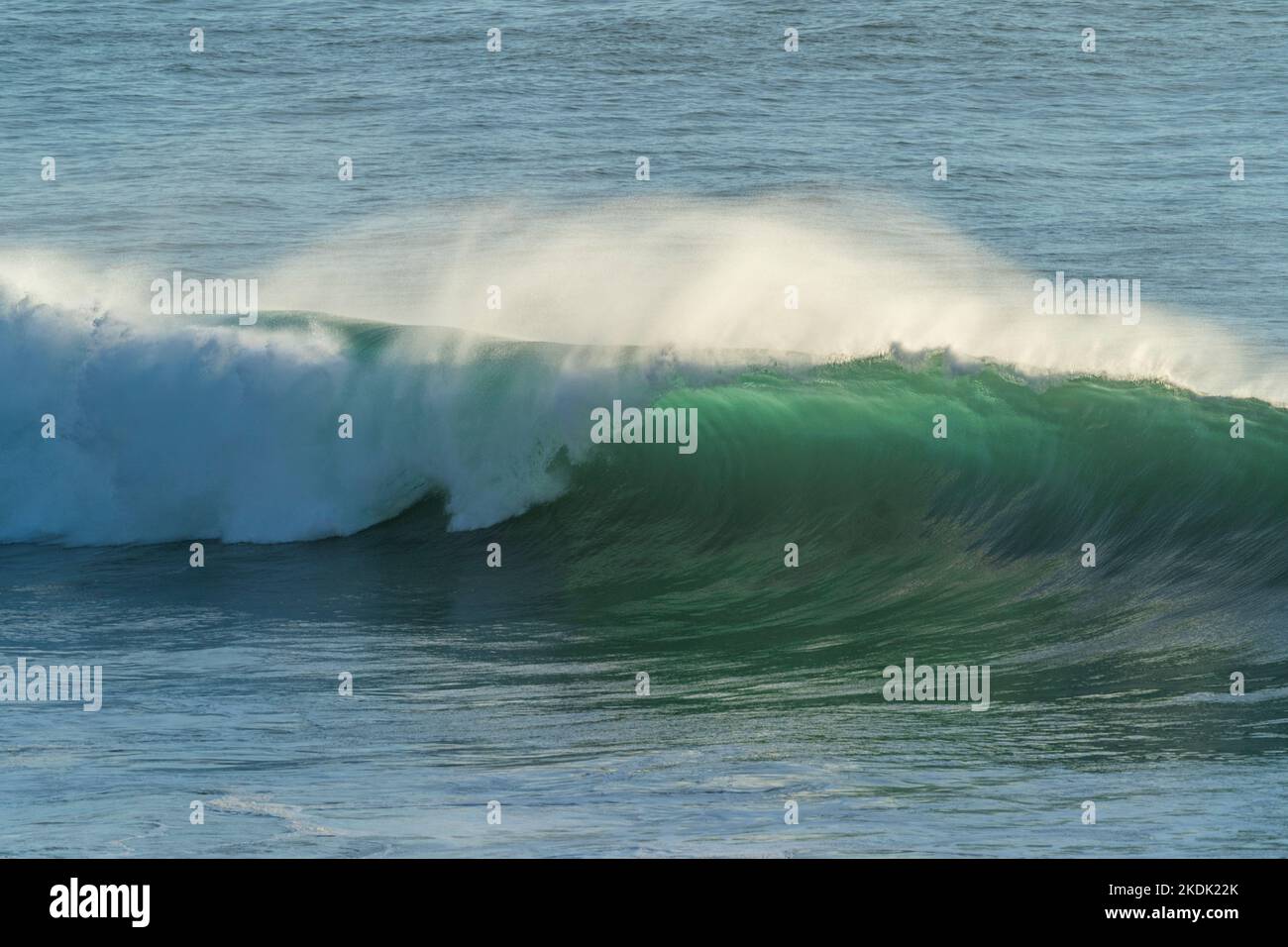 Perfect wave breaking on a offshore wind bright sunny day on a sandy ...