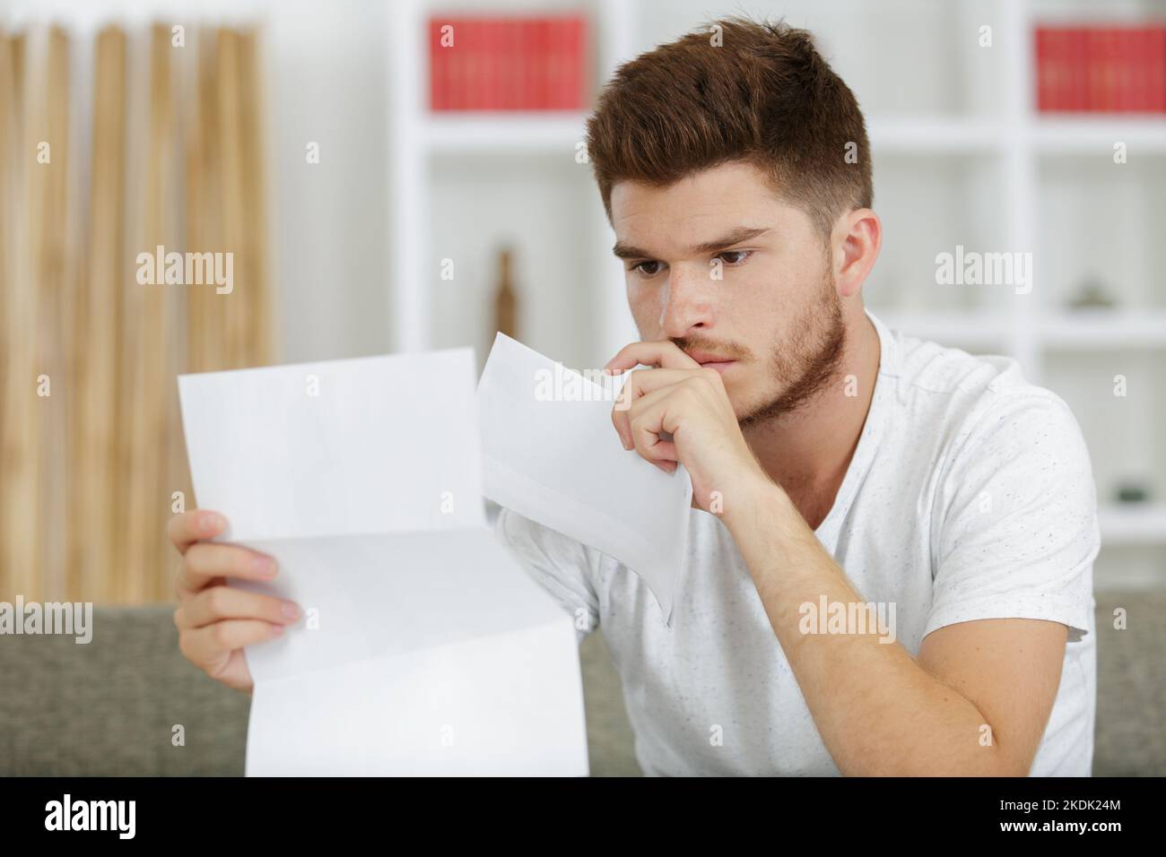 young man reading a letter with serious gesture Stock Photo - Alamy