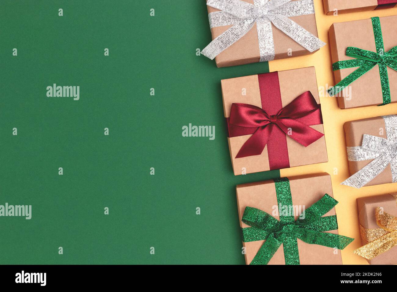 Gifts tied with multicolored ribbons on a green and golden background ...