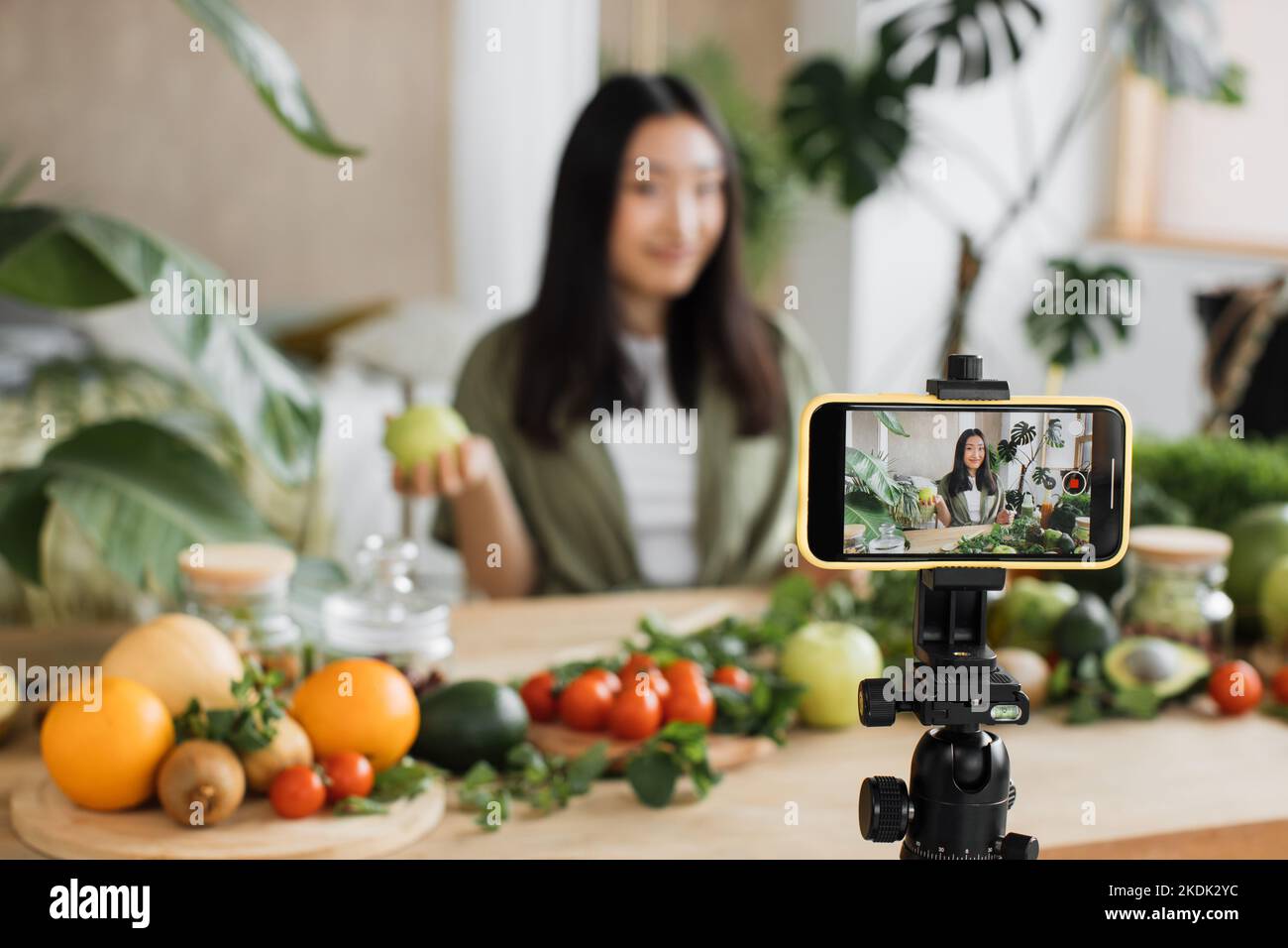 Smiling young asian woman cooking vlogger live-streaming her video blog ...