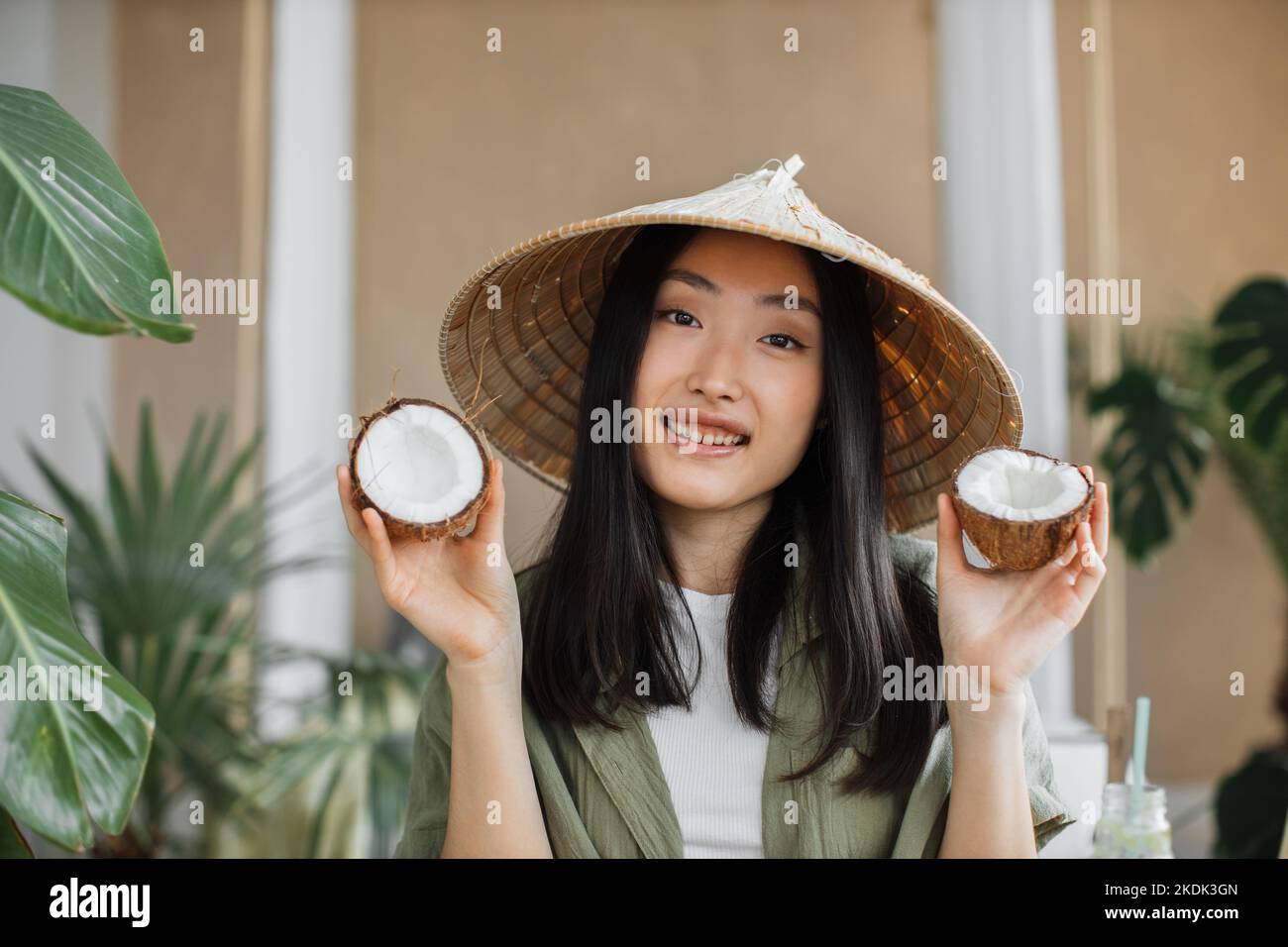 Fashion. Asian woman in summer clothes with coconut in tropical nature ...