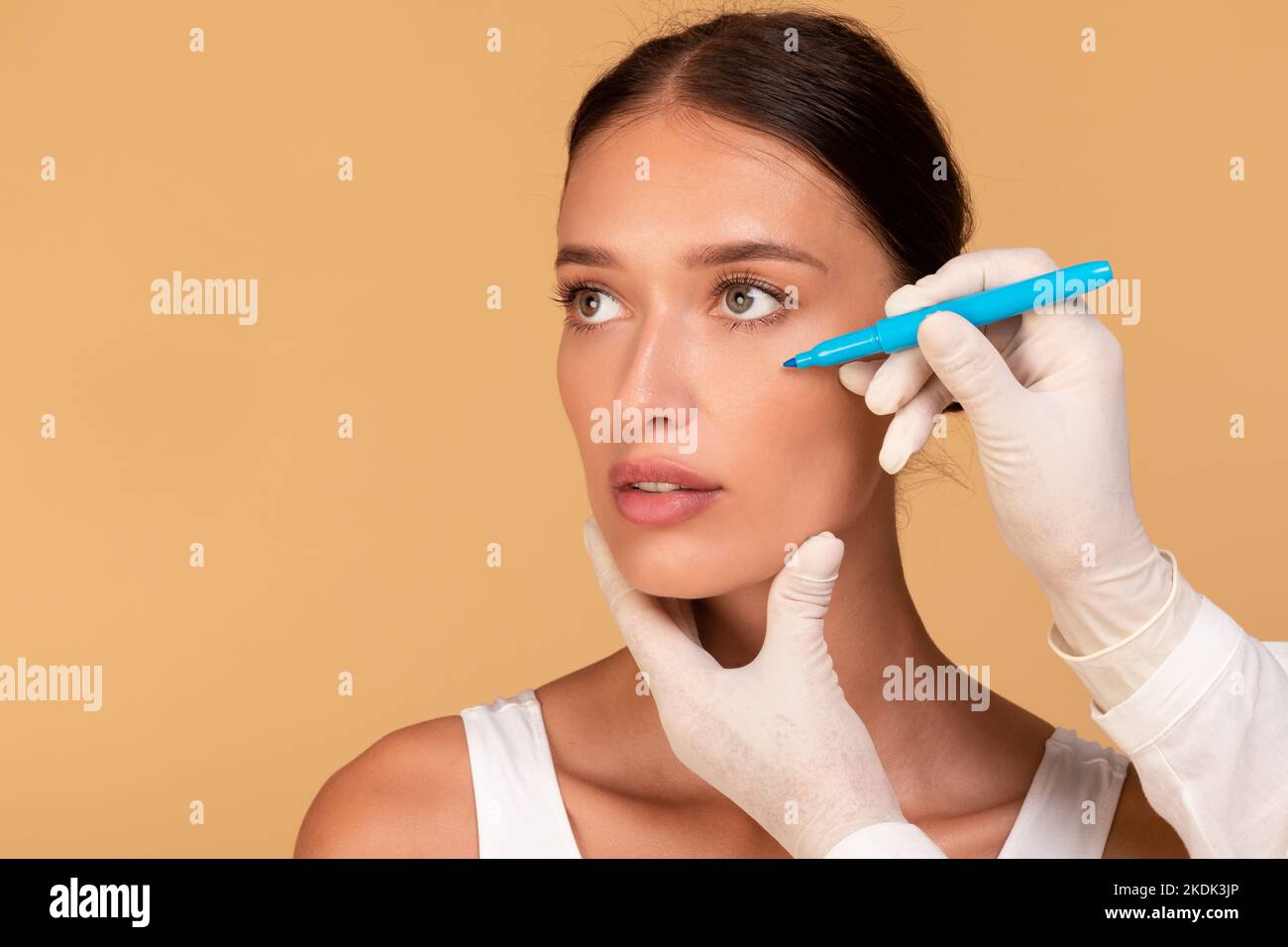 Plastic surgeon drawing lines on young woman's face for cosmetic ...