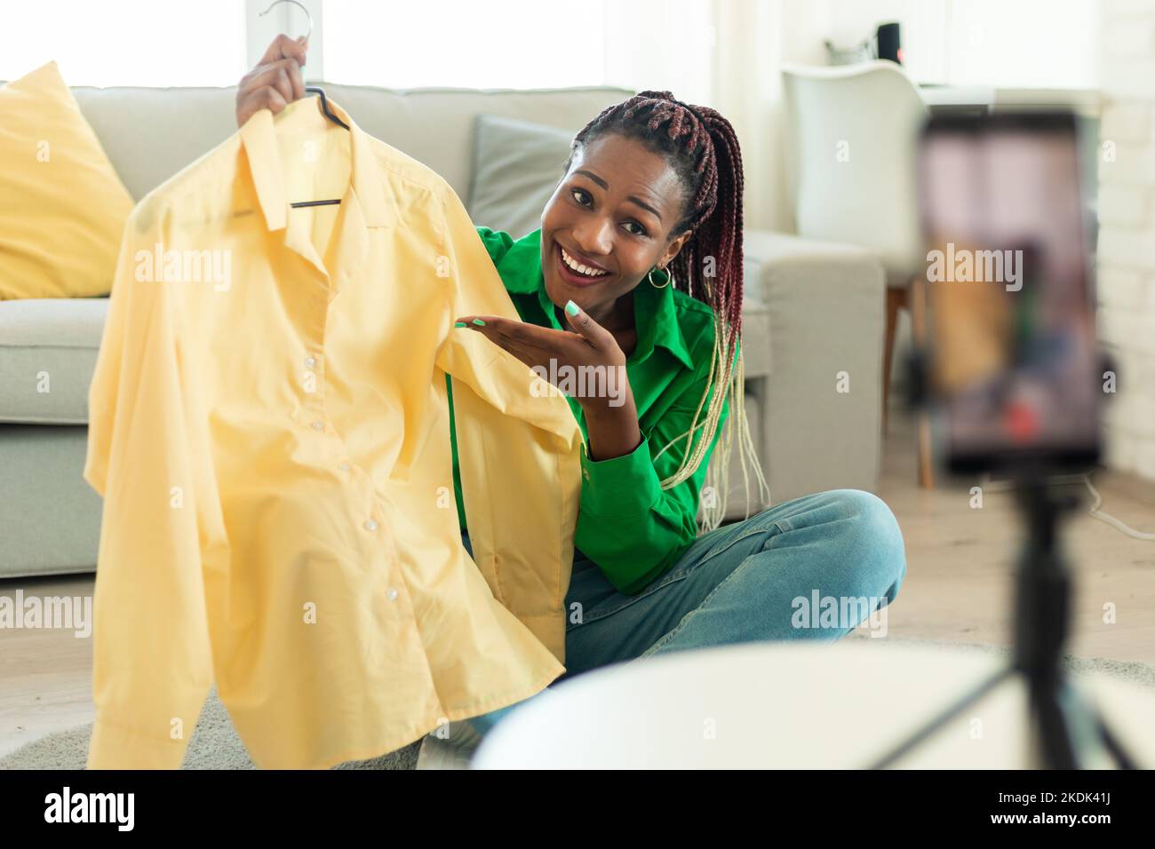 Happy black female blogger making video review with new clothes after ...