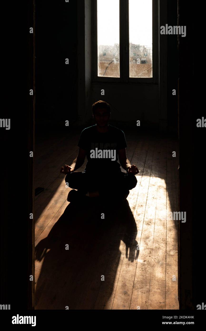 Sun sending its rays through a window throwing its shadows on a man ...