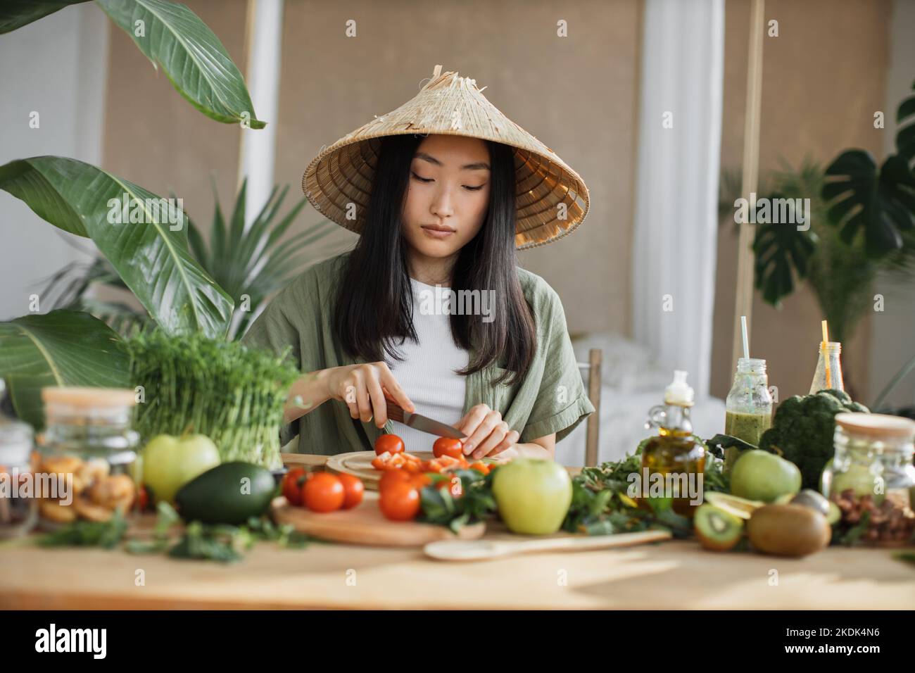 Young asian woman blogger or content creator chopping tomatoes ...